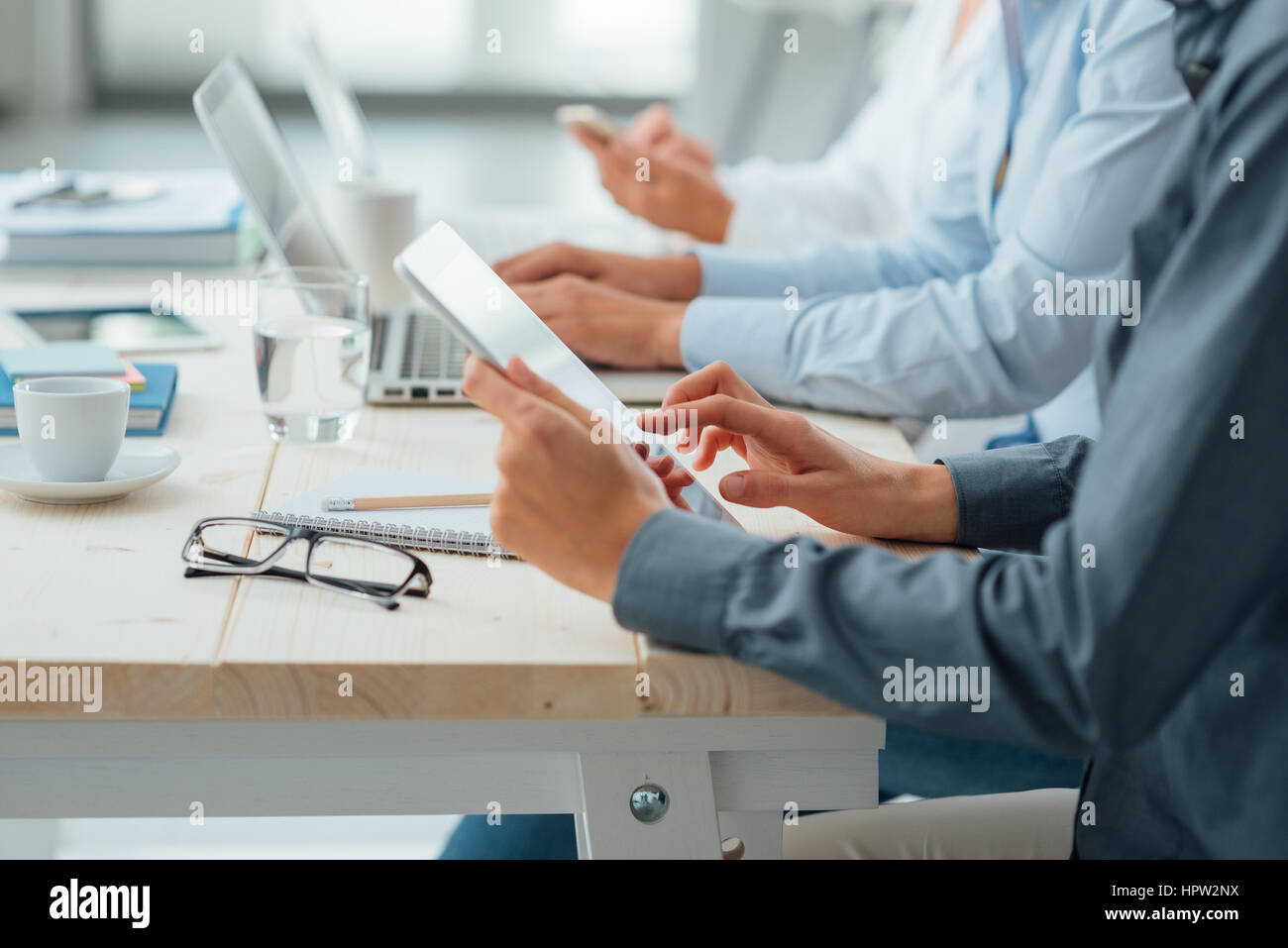 Business team working at office desk using a tablet, a laptop and a ...