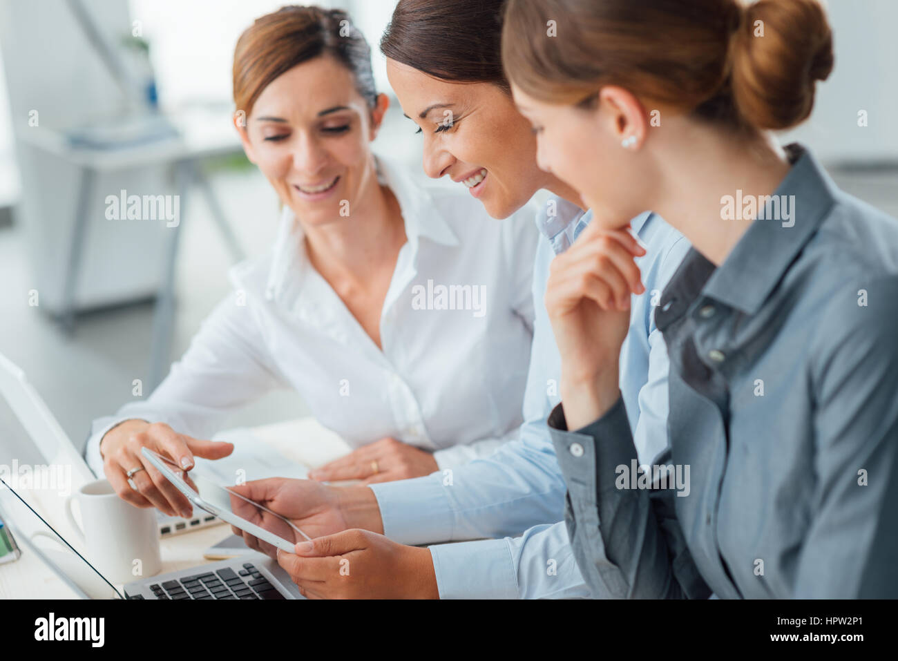 Successful smiling business women team working at office desk and ...
