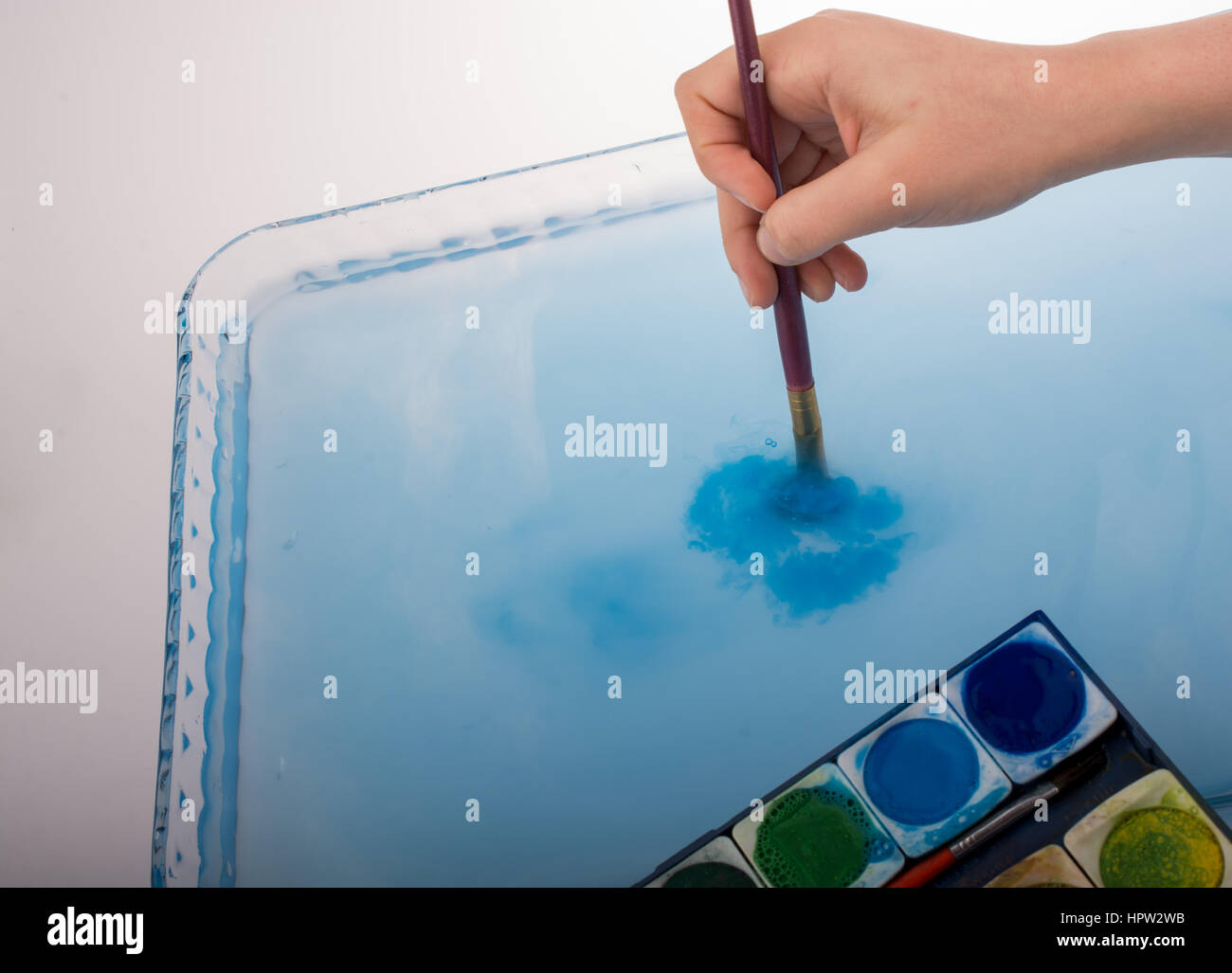 Paint dissolving in water as painting brush touching water Stock Photo ...