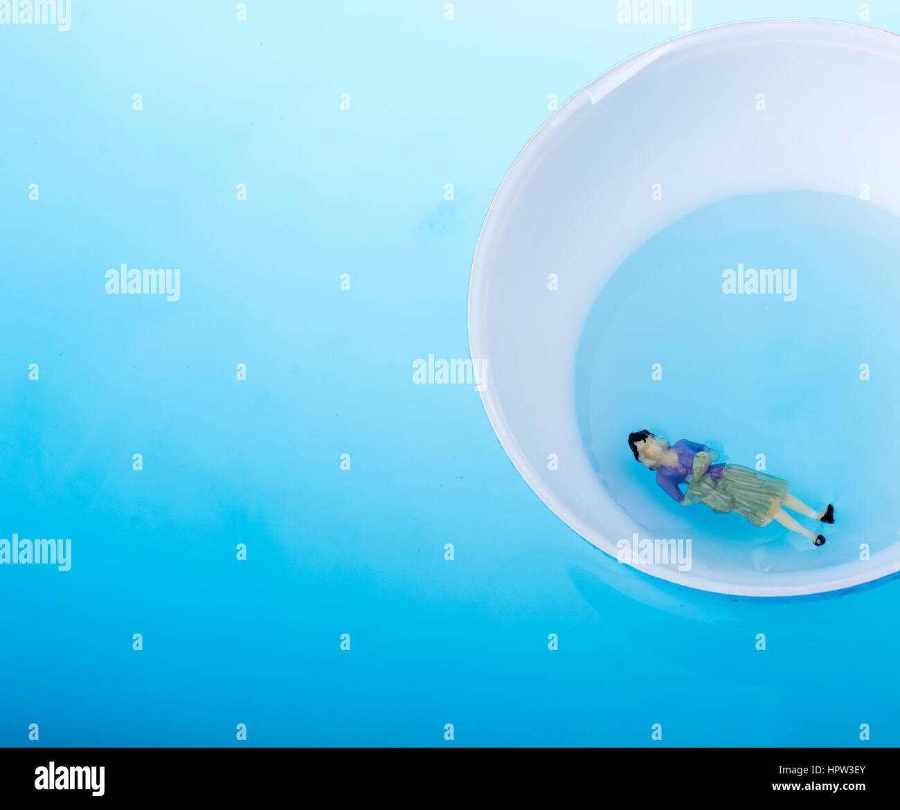 Little model globe with figurine floating in blue water Stock Photo - Alamy