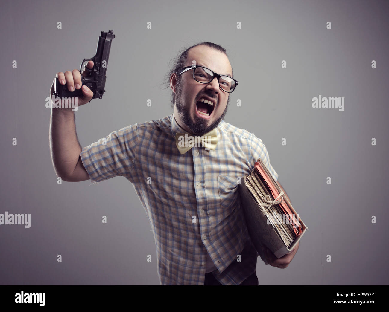 Office worker shouting with a gun on grey background Stock Photo - Alamy