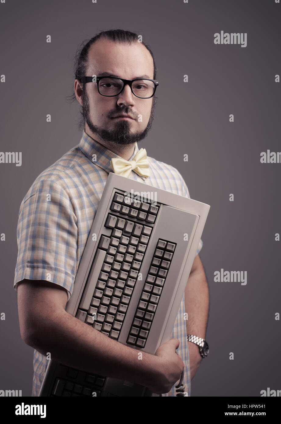 Funny guy posing with a keyboard on grey background Stock Photo - Alamy