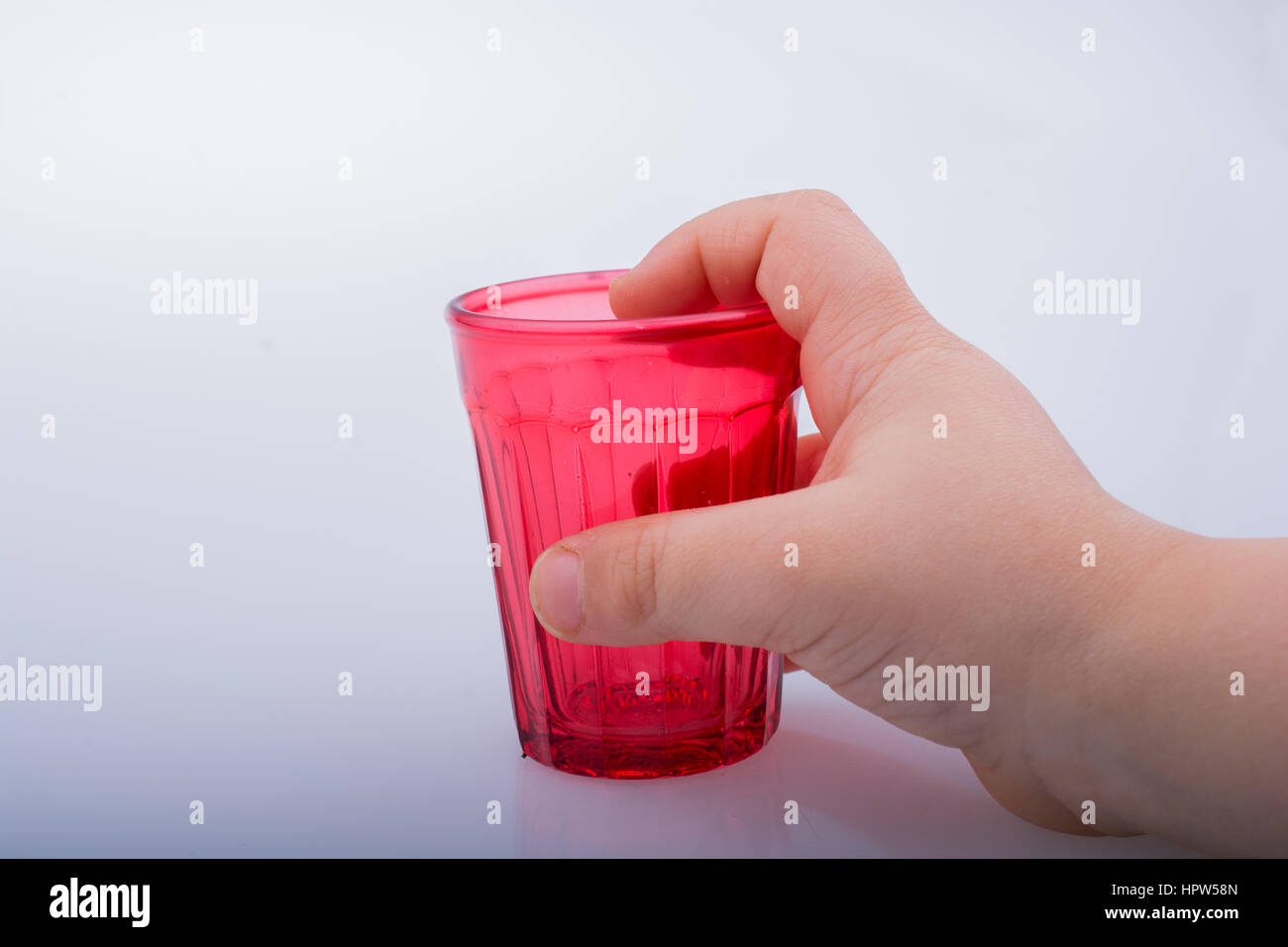 Drinking glasses of red color in hand with patterns Stock Photo - Alamy