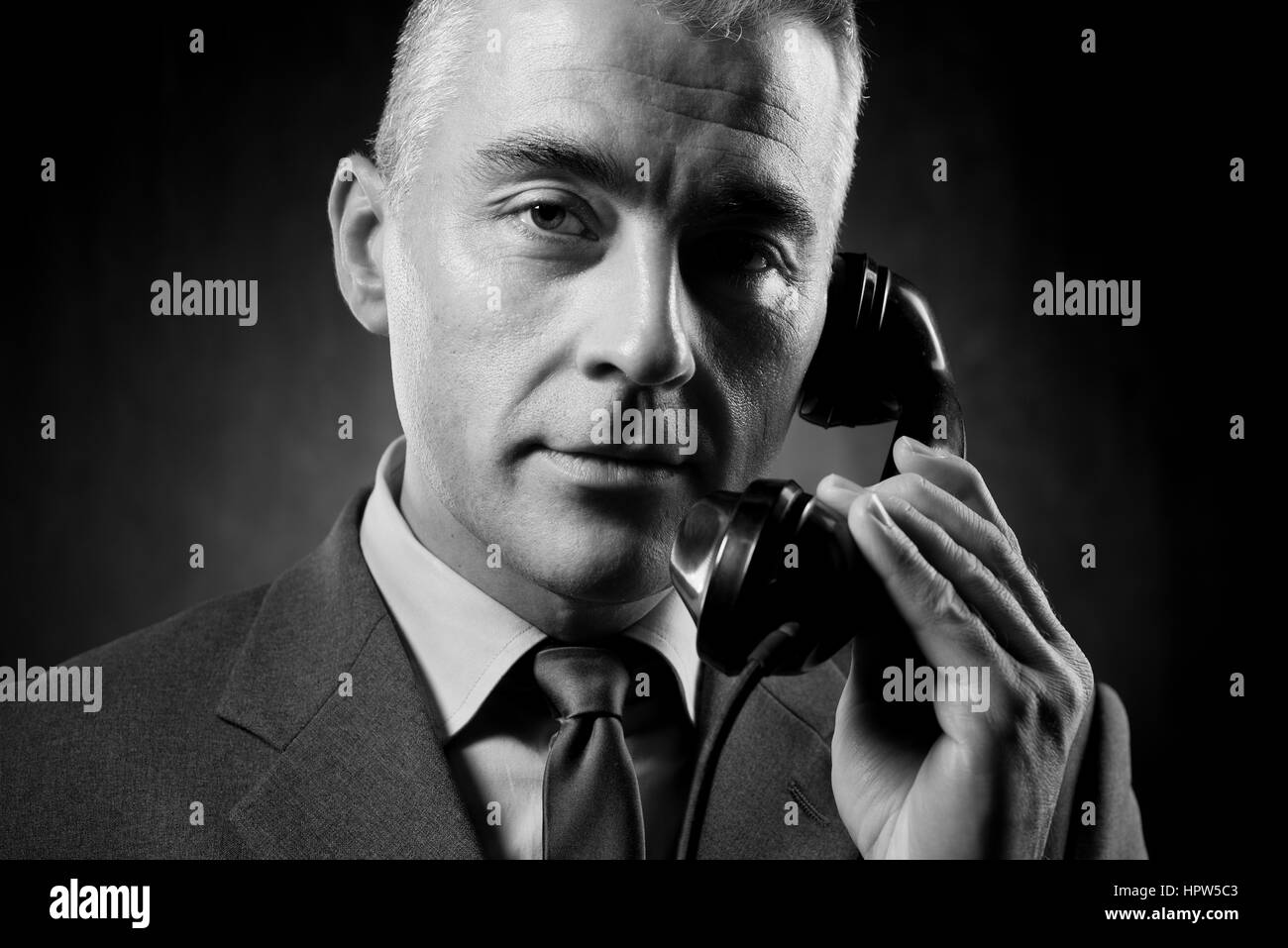 Handsome man holding a vintage phone receiver on dark background Stock ...