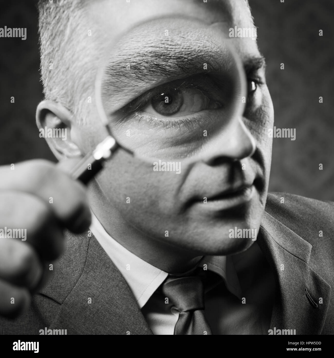 Vintage detective looking at camera through magnifying glass Stock ...