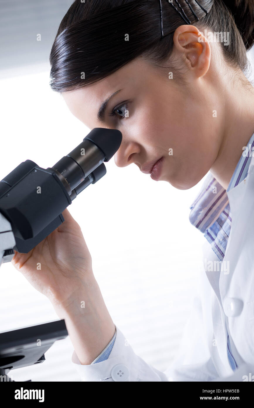 Young female researcher using microscope in the laboratory close up ...
