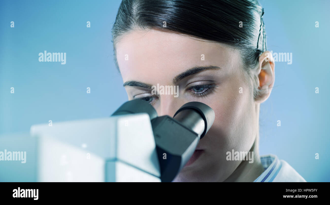 Young female researcher using microscope in the laboratory close up ...