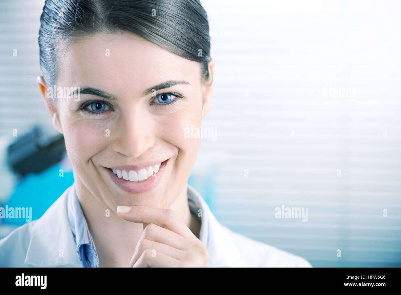 Young confident female researcher smiling with hand on chin Stock Photo ...