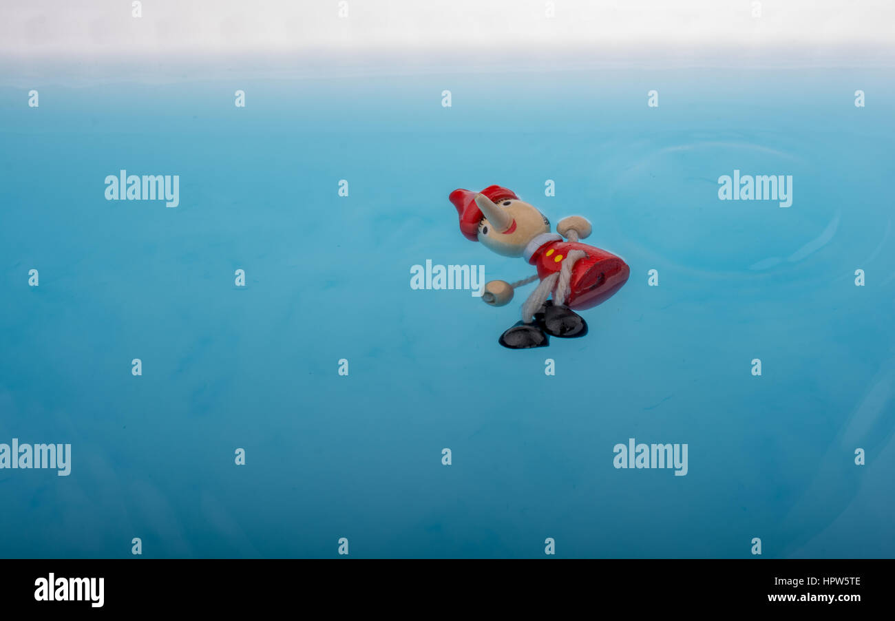 Wodden puppet Pinocchio on in blue water Stock Photo - Alamy