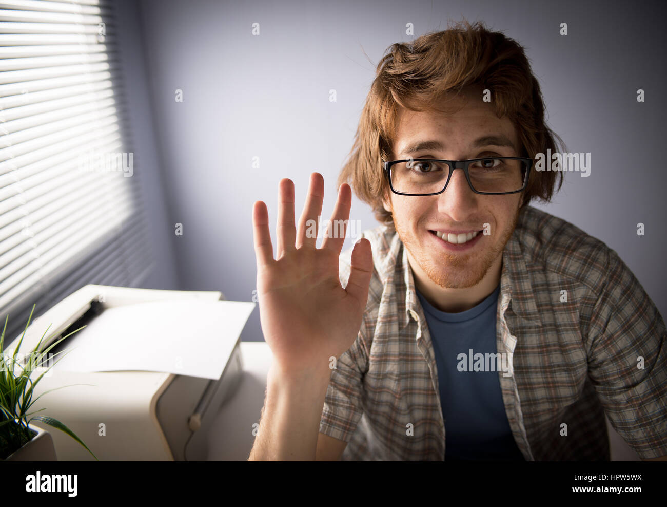 Young man video calling and waving hand with funny expression Stock ...