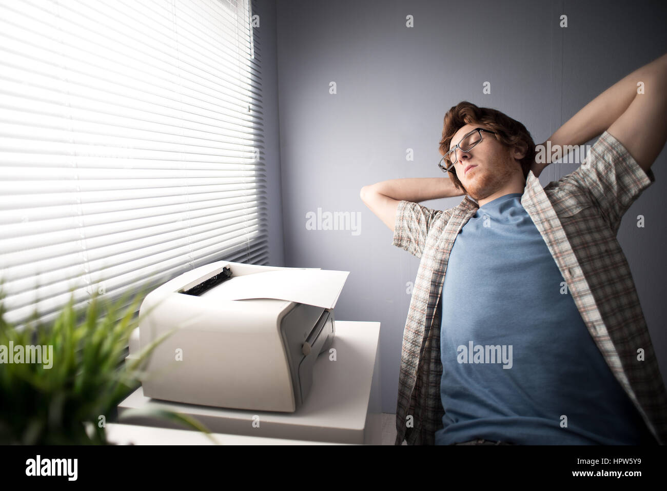 Young tired man relaxing and stretching at workplace Stock Photo - Alamy