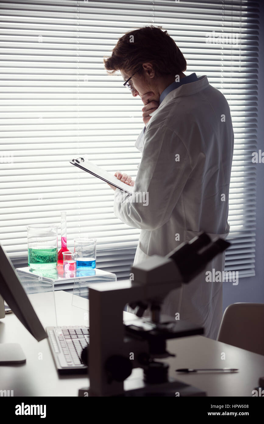 Researcher reading medical records in the chemical laboratory with ...