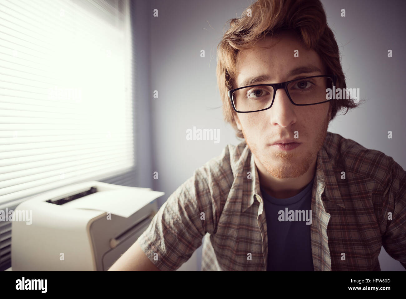 Young nerd guy staring at monitor with pensive expression Stock Photo ...