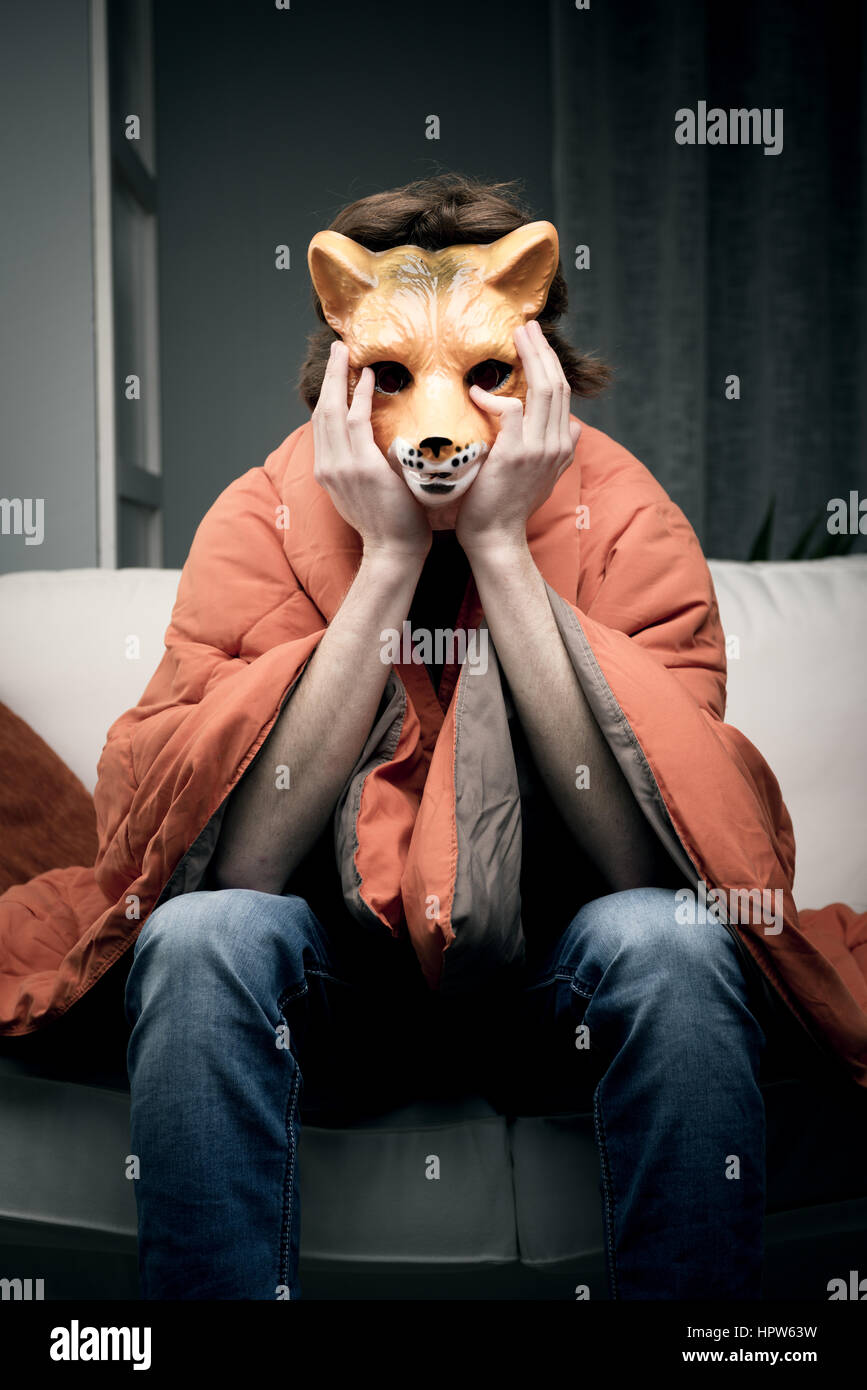 Young depressed man wearing a fox mask covered with a blanket Stock ...