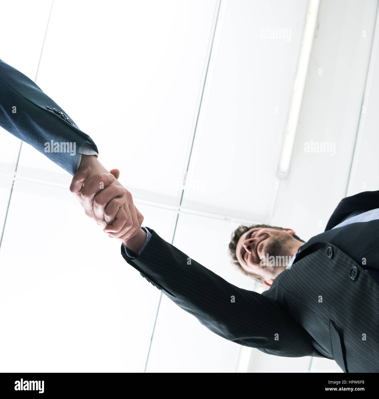 Confident young businessmen smiling and shaking hands bottom view Stock ...