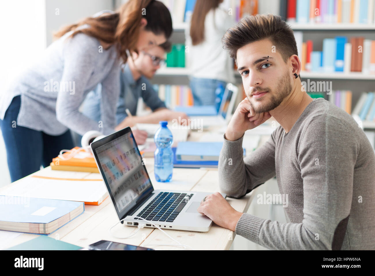 Group of college students doing homework and studying together, they ...