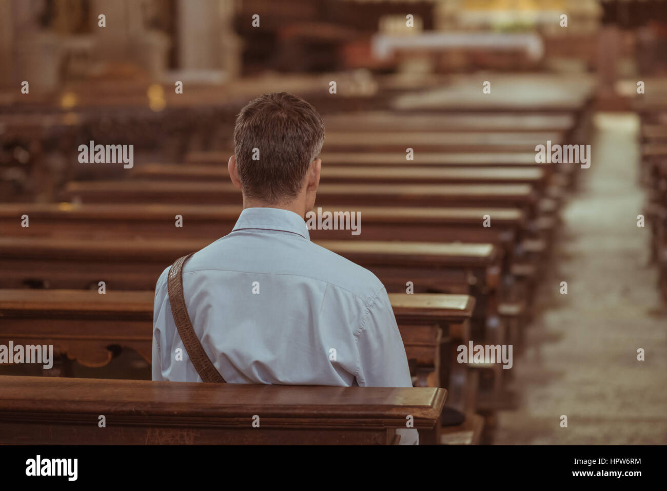 Man sitting in a pew at Church and meditating, faith and religion ...