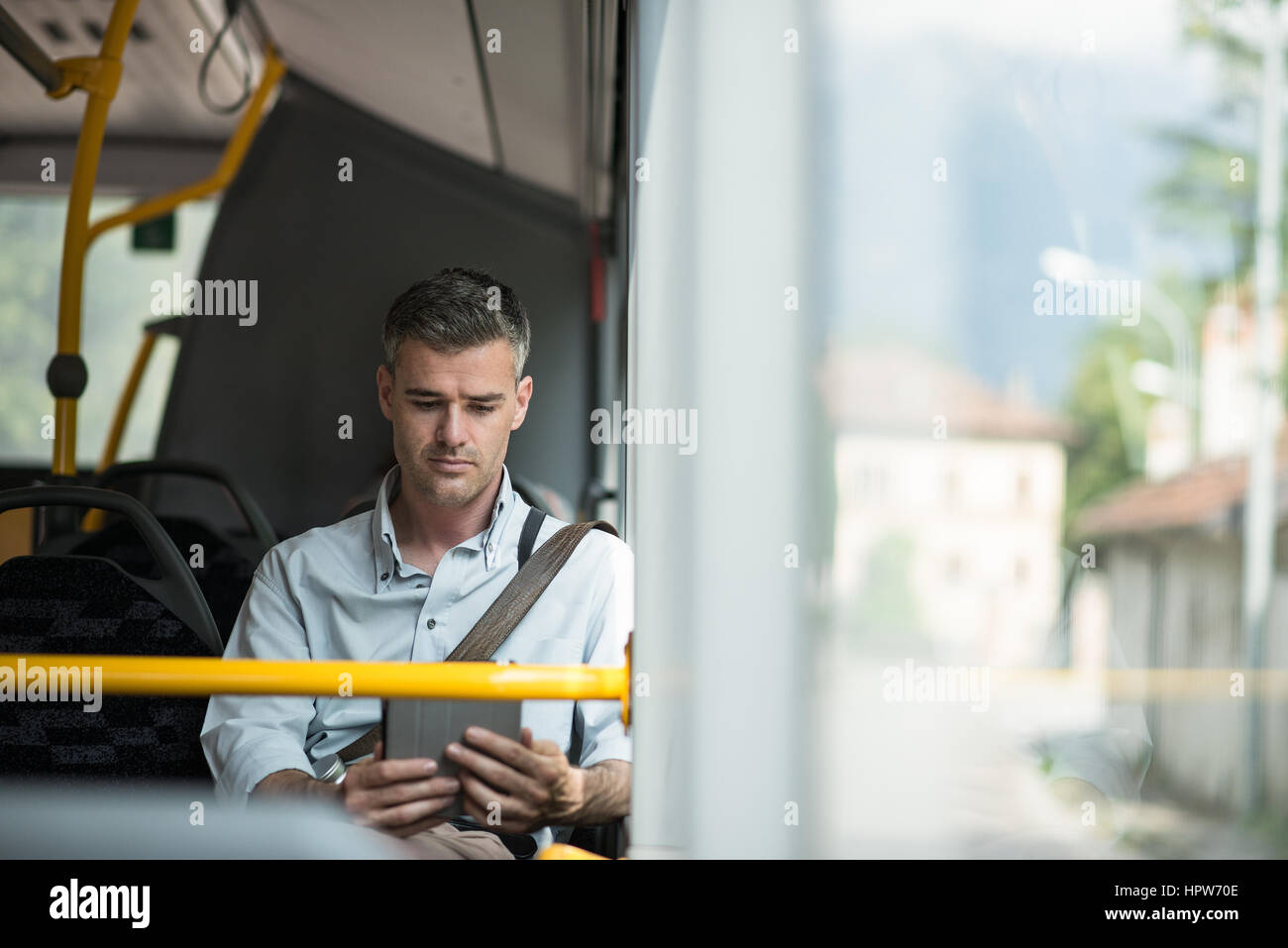 Businessman commuting to work by bus and working with a digital touch ...