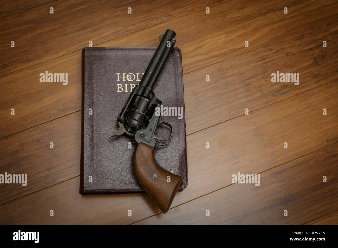 a revolver on a brown bible Stock Photo - Alamy