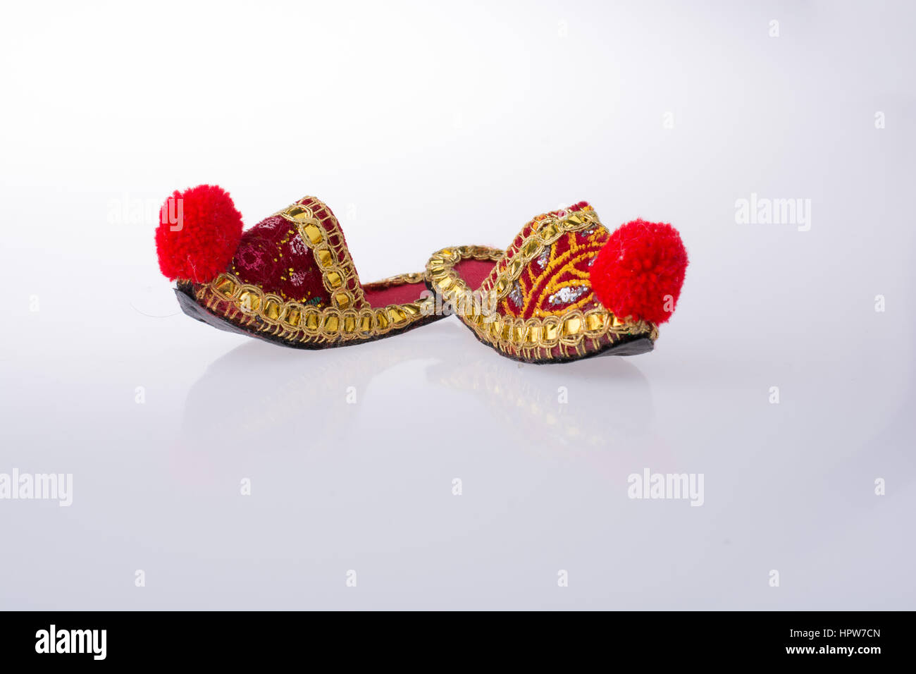 Hand holding traditional Turkish handmade shoes on white background ...