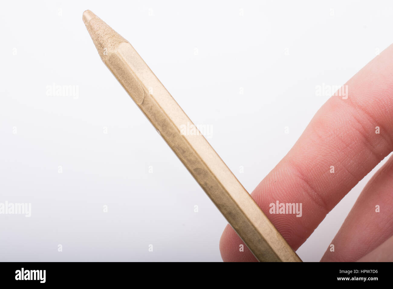 Hand holding a gold color pencil on a white background Stock Photo - Alamy
