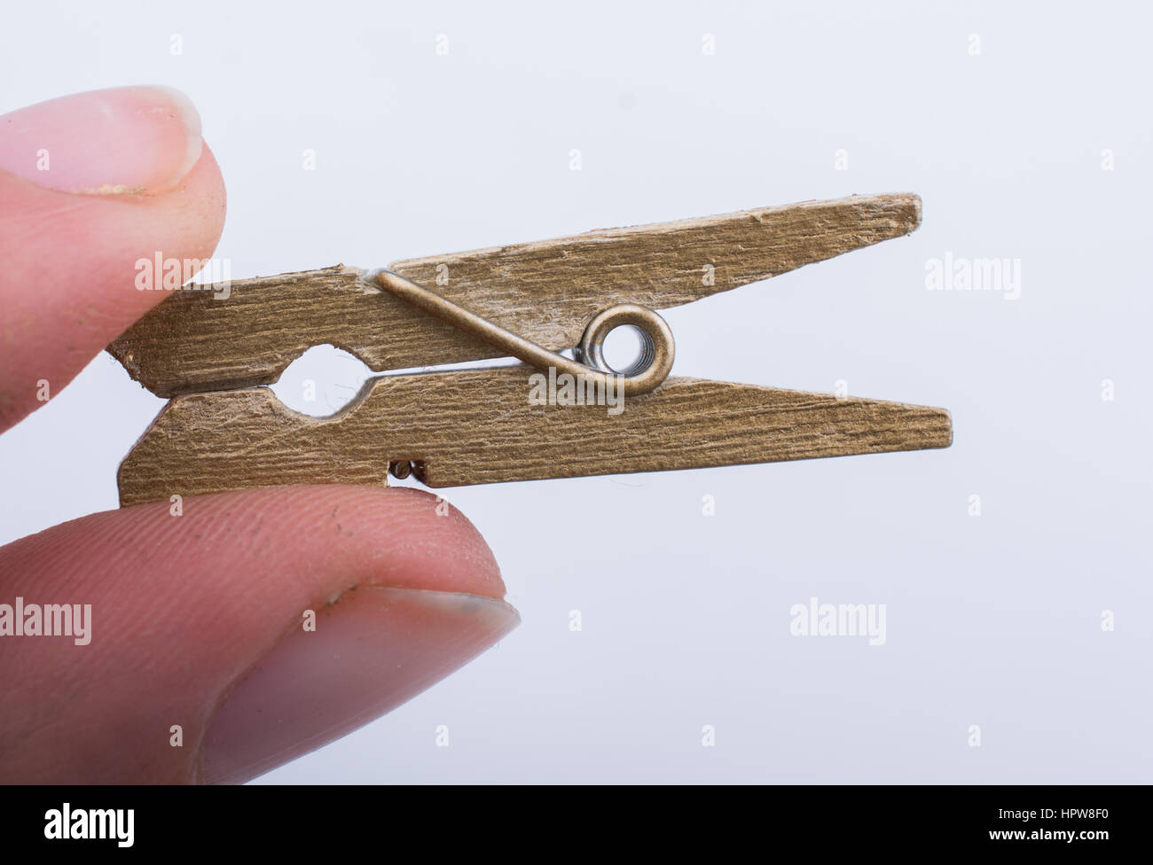 Hand holding a small wooden clothespin in hand Stock Photo - Alamy