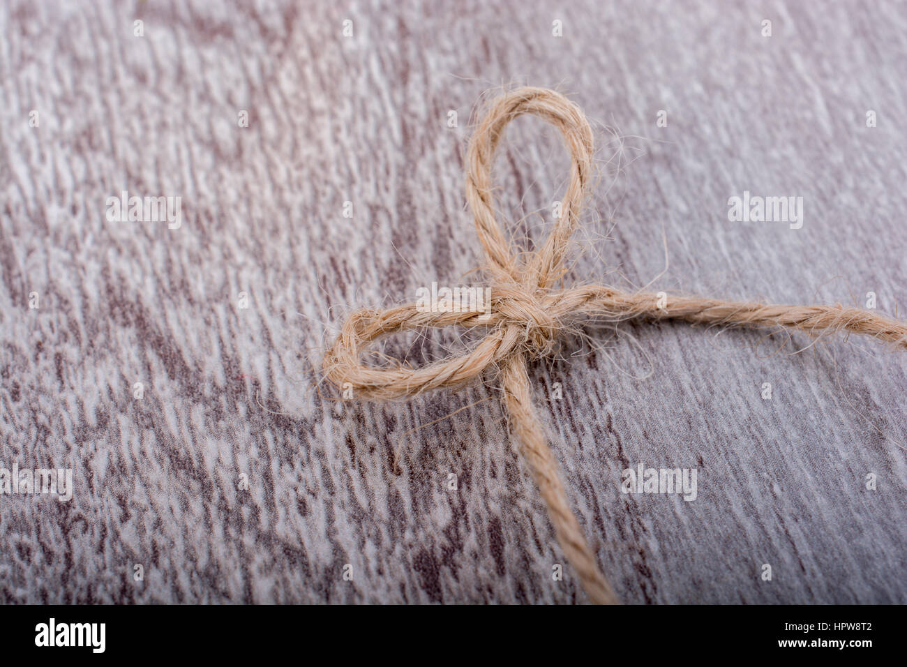 Thread tied as knot on a light color background Stock Photo - Alamy