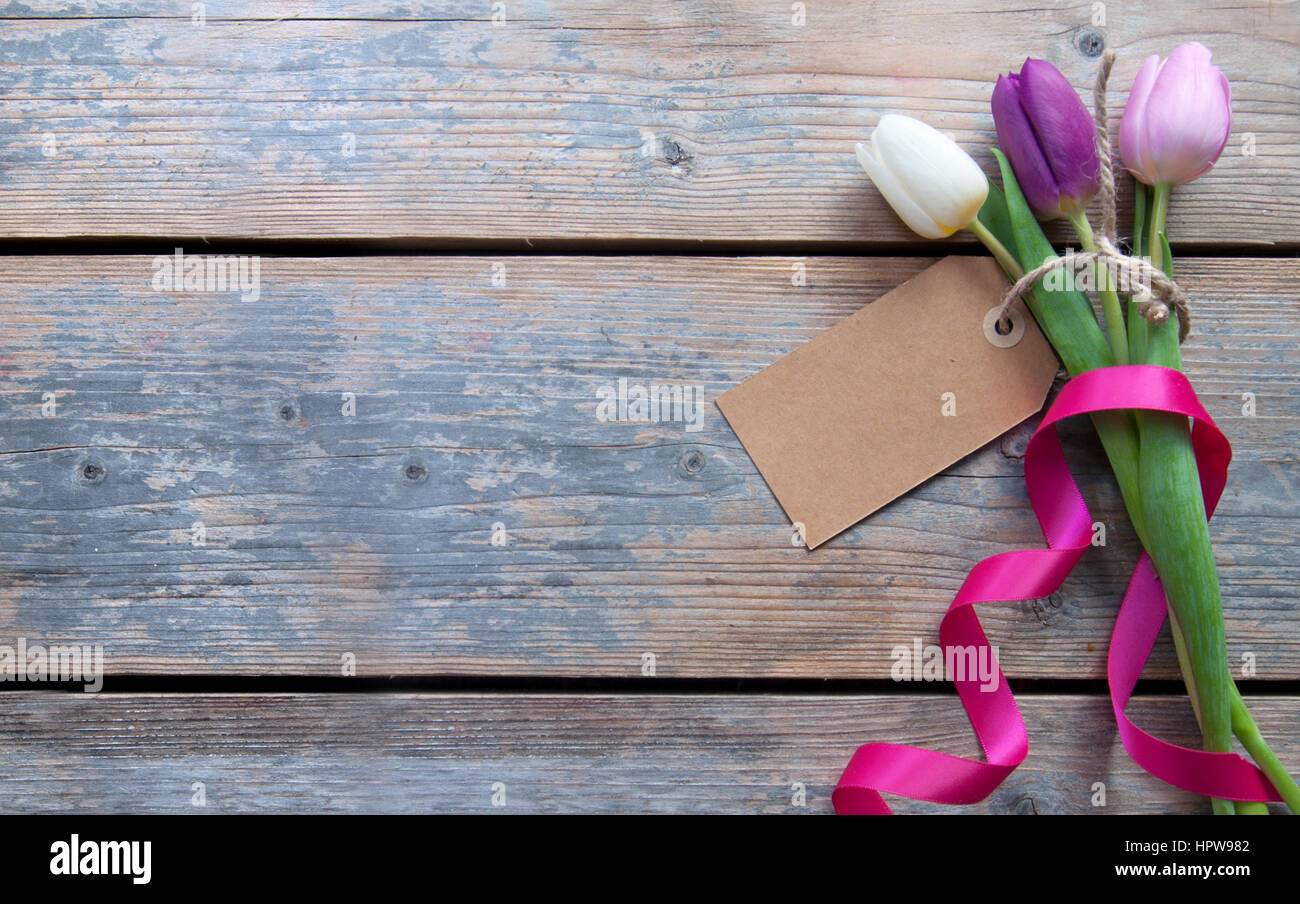 Label attached to spring tulips with decorative ribbon Stock Photo - Alamy