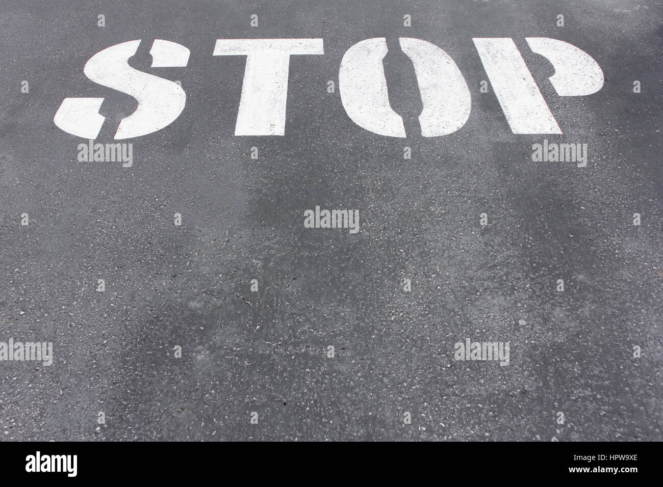 Word stop written on asphalt road texture Stock Photo - Alamy