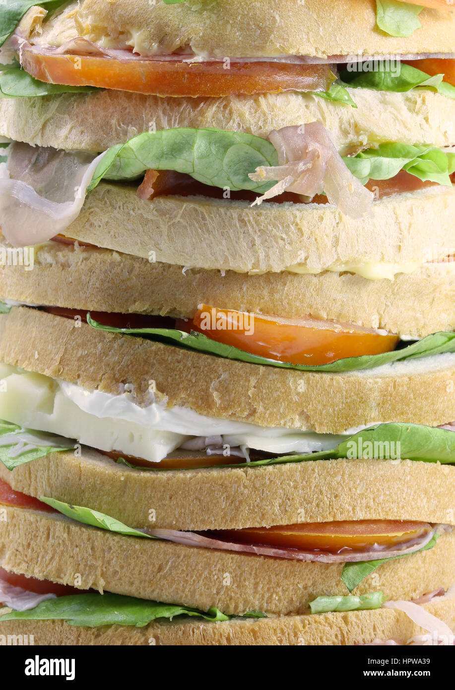 giant sandwich stuffed with many layers of bread with lettuce tomato ...