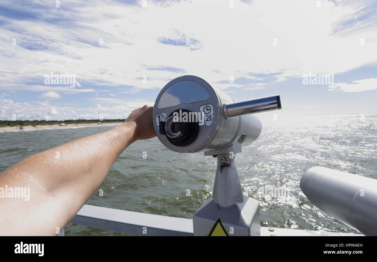 Telescope in hand towards to coast of seaside Stock Photo - Alamy