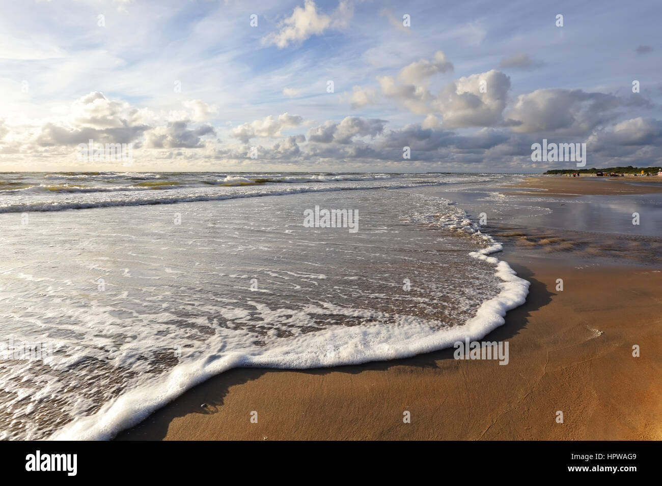 Summer sunset on beach with small wave on front Stock Photo - Alamy