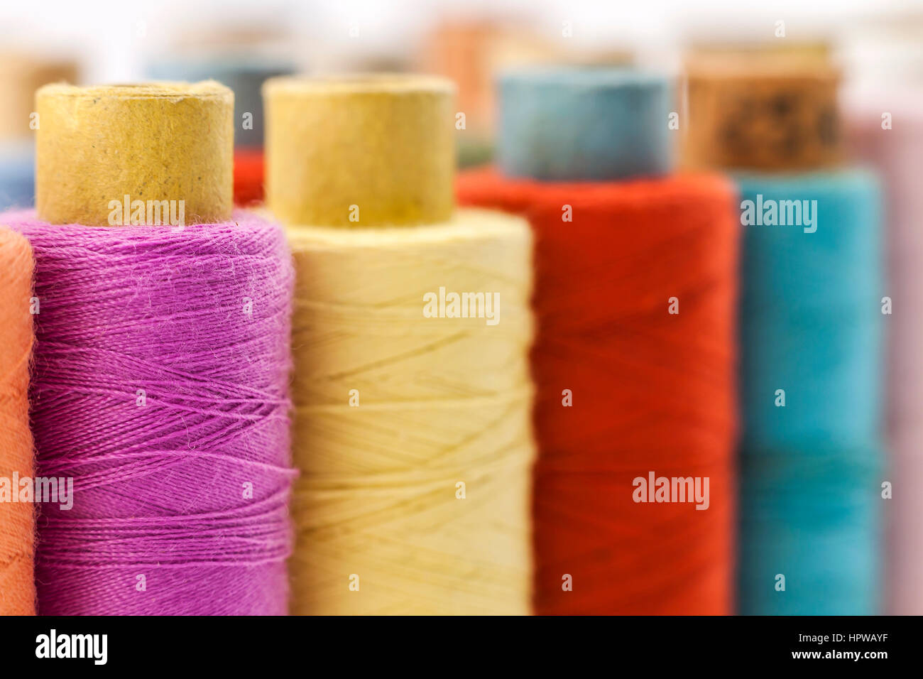 Reels or spools of multicolored sewing threads. Threads of all colors ...