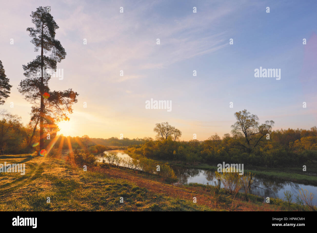 Spring sun rising above lake with star shape rays from sun Stock Photo ...