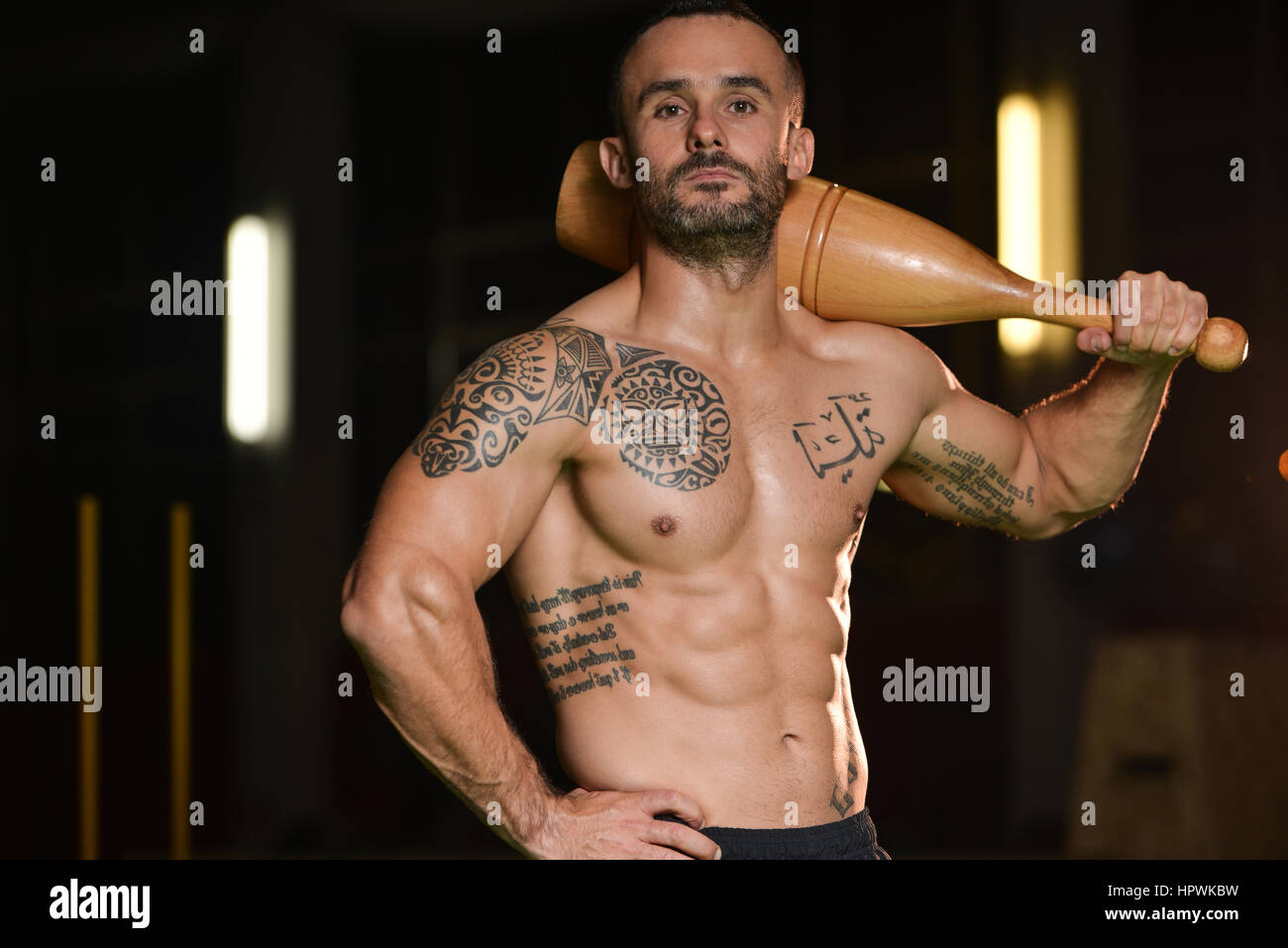 Young Man Working Out With Bowling Pin In A Gym - Bodybuilder Doing ...