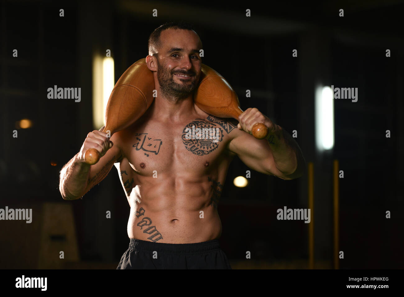 Young Man Exercising With Bowling Pin And Flexing Muscles - Muscular ...