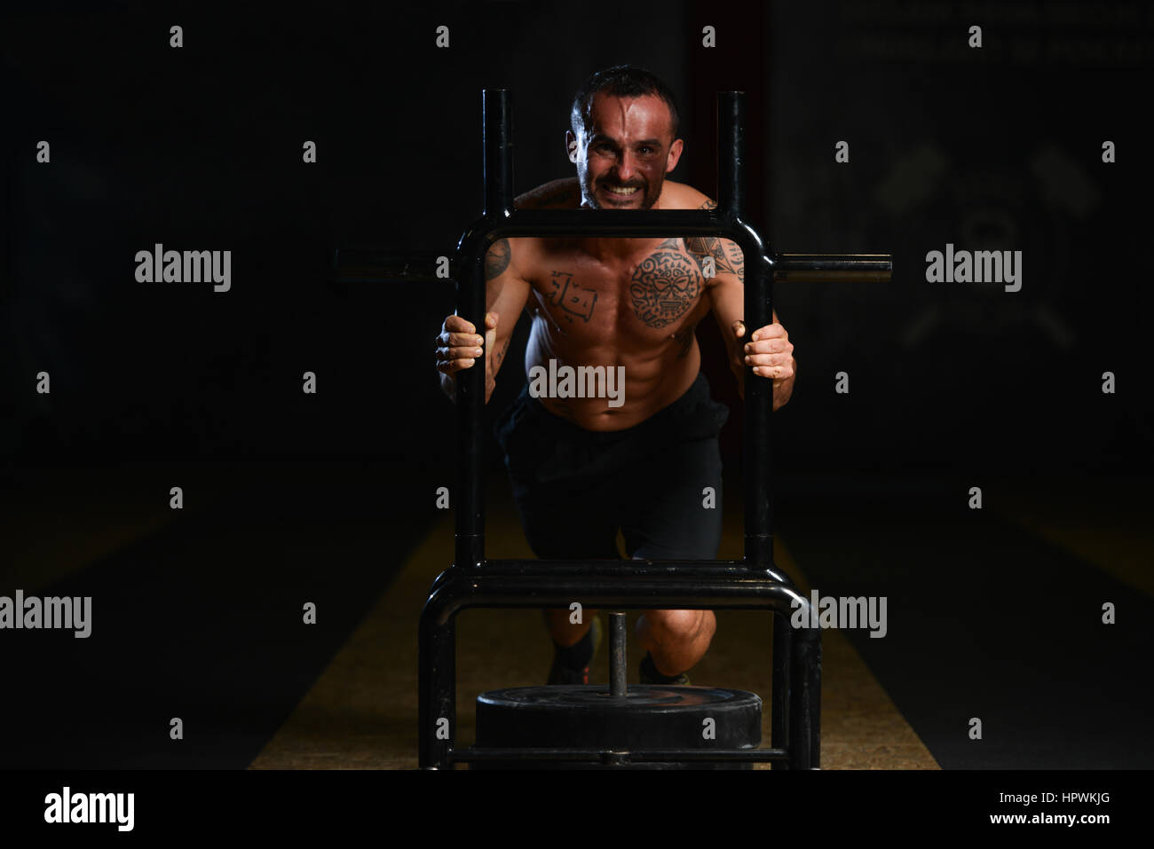 Muscular Man Doing Heavy Weight Exercise Weighted Speed Sled In Gym ...