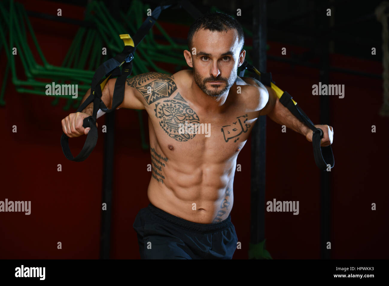 Attractive Man Does Crossfit With Trx Fitness Straps In The Gym's ...