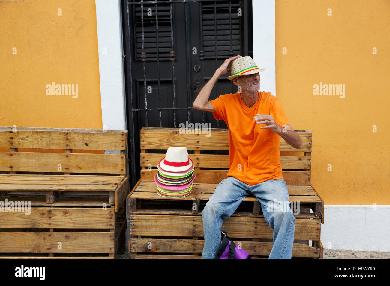 Man selling hats sitting on a bench, San Juan, Puerto Rico Stock Photo ...