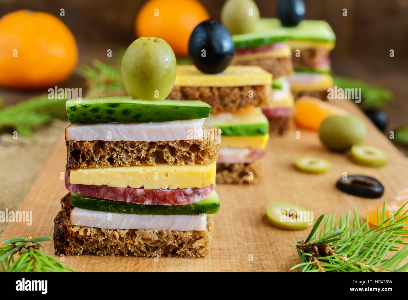 Mini sandwiches (canape) with fresh cucumbers, ham, cheese, olives ...