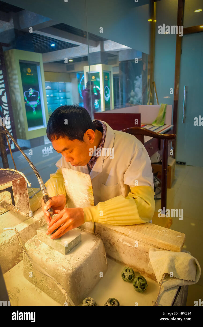 BEIJING, CHINA - 29 JANUARY, 2017: Jade craftsman sitting by desk using ...