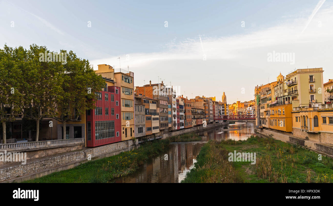 Onyar river crossing the downtown of Girona with bell tower of Basilica ...