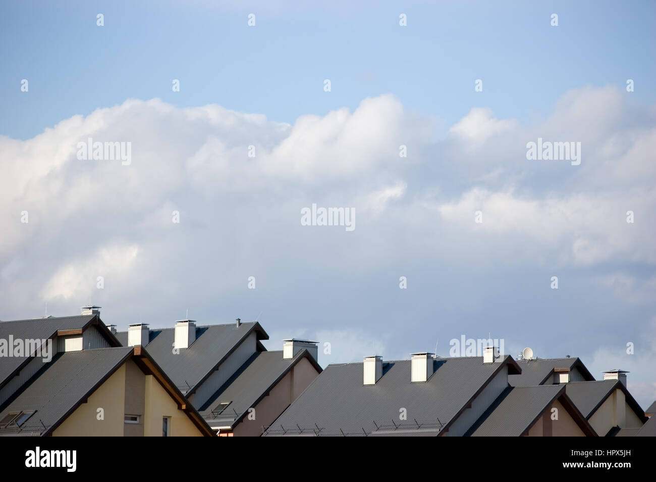 Row house roofs, condo houses rooftop panorama, bright summer clouds ...
