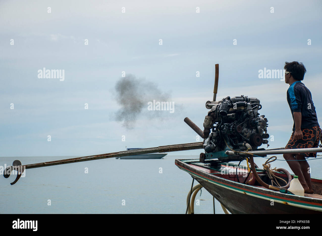 Thai traditional longtail boat with big diesel engine in action smoke ...