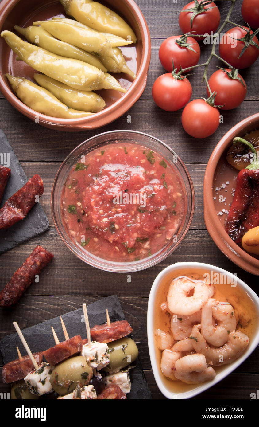 Mixed spanish tapas appetizers on dark brown wooden table. Top view ...