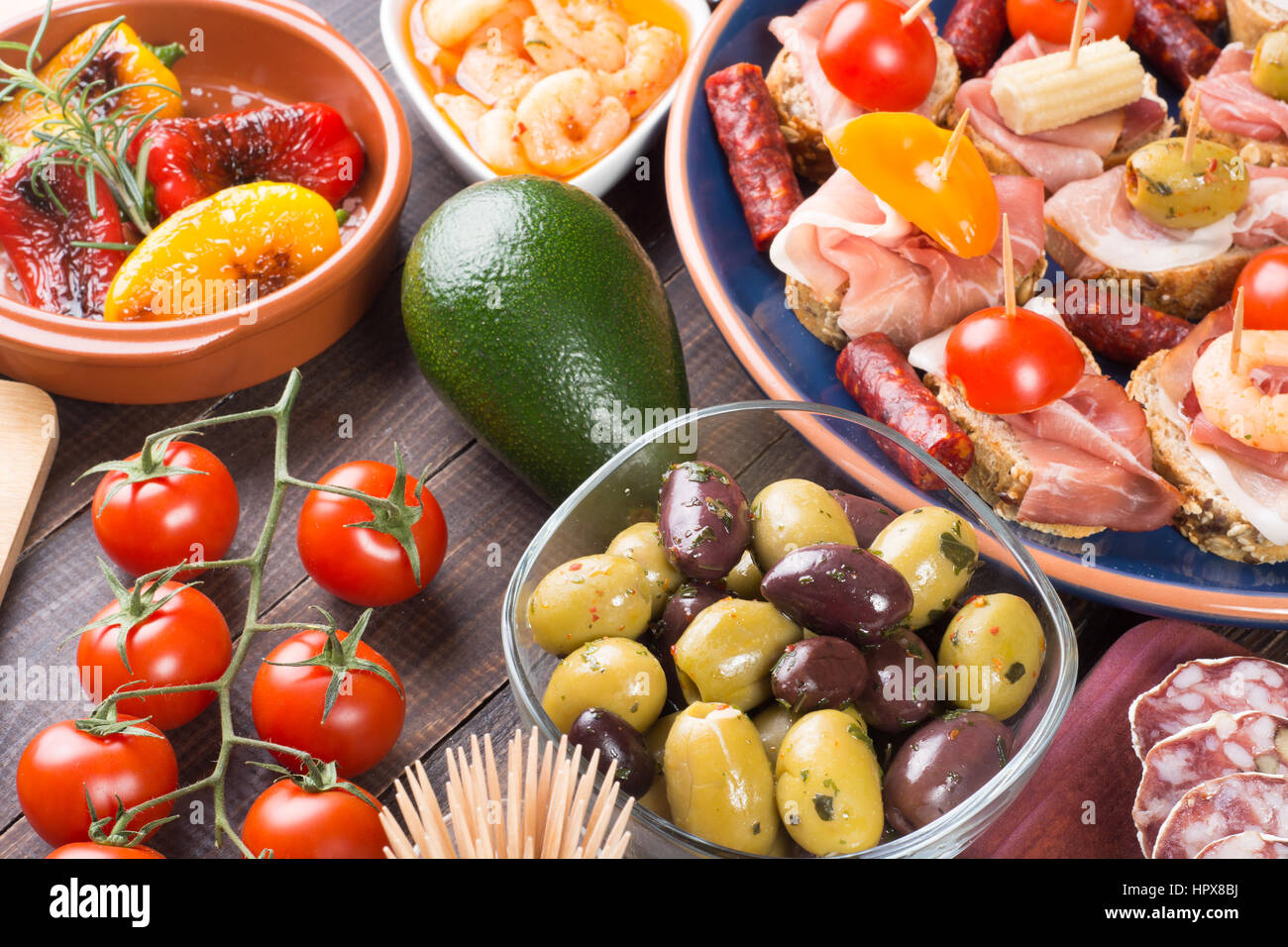 Mixed spanish tapas appetizers on dark brown wooden table. Top view ...