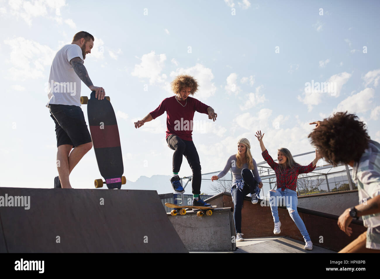 Friends skateboarding at sunny skate park Stock Photo - Alamy