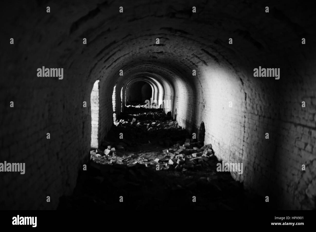 Scary brick arch tunnel on dark and some light Stock Photo - Alamy