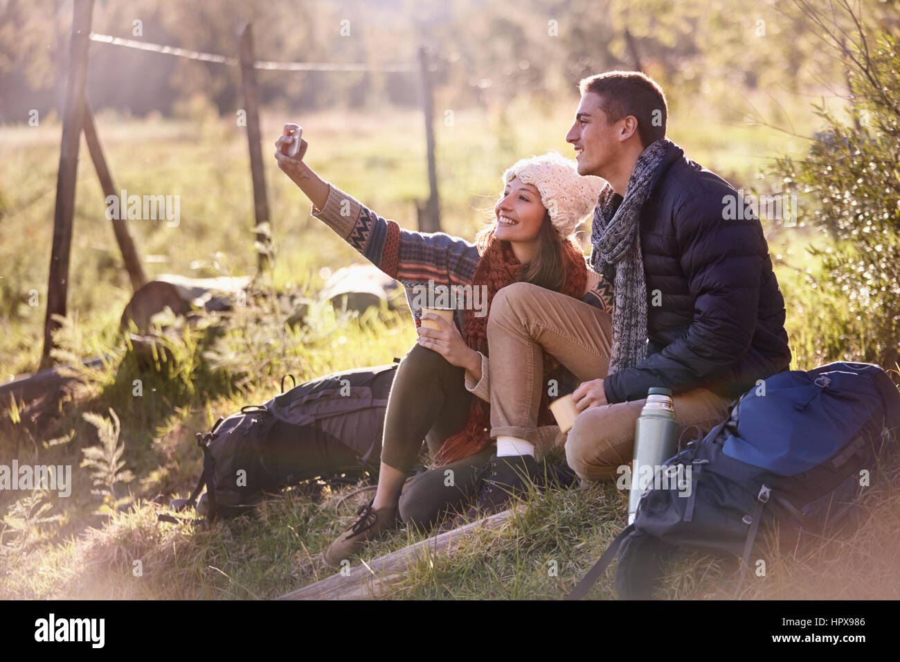 Young couple taking a break from hiking, taking selfie with camera ...