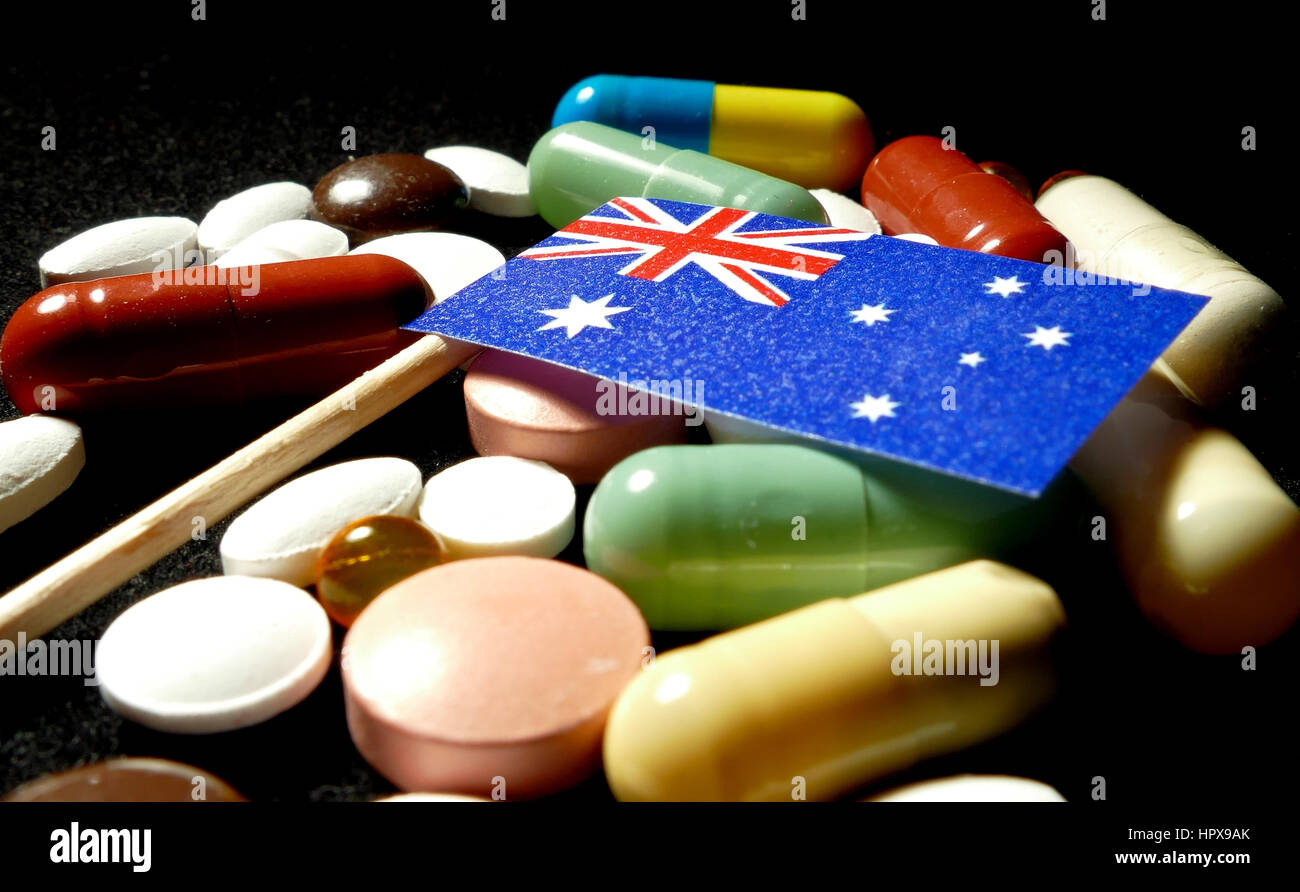 Australian flag with lot of medical pills isolated on black background ...